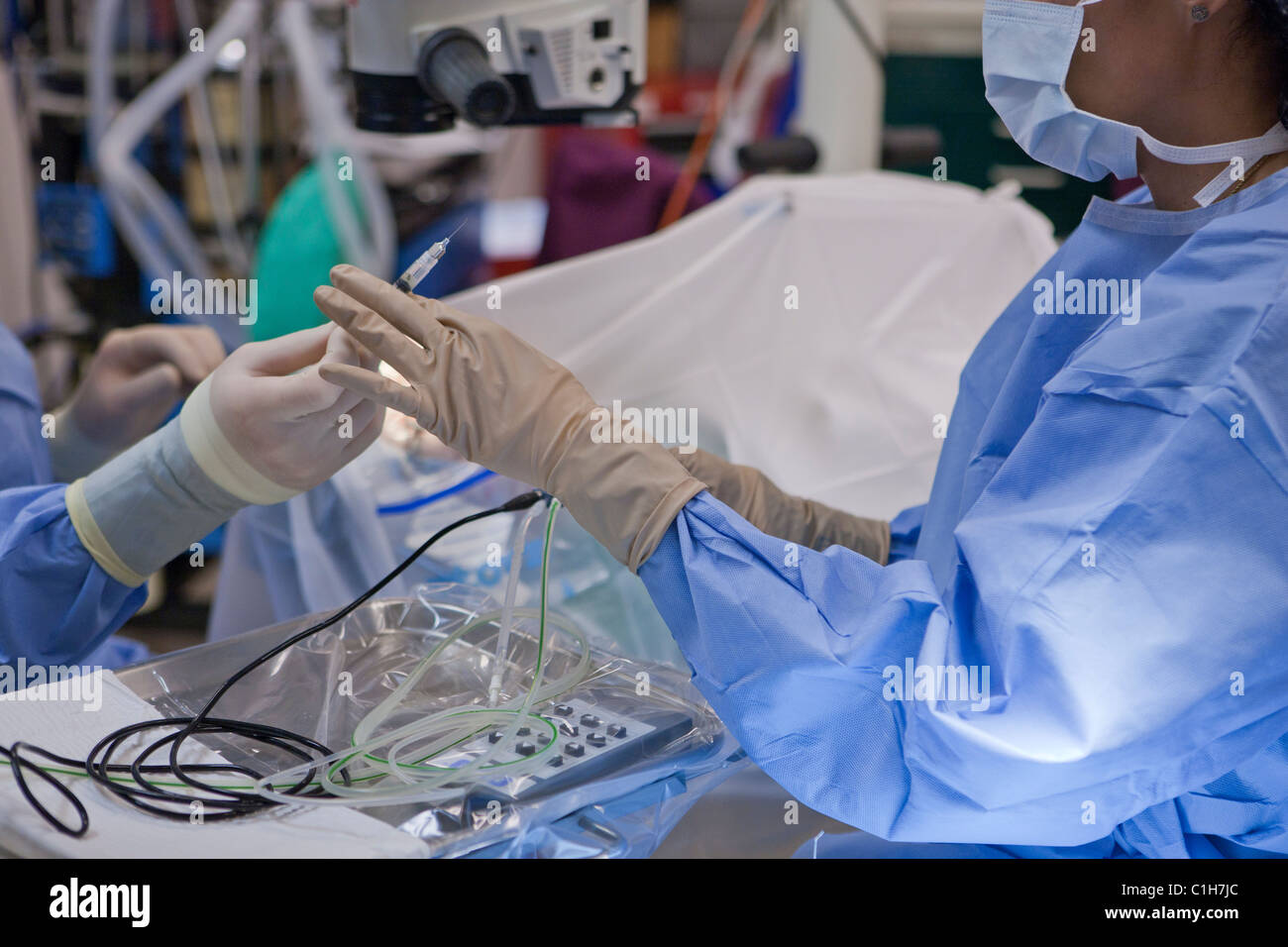 Ophthalmologist performing cataract surgery with surgical technologist ...
