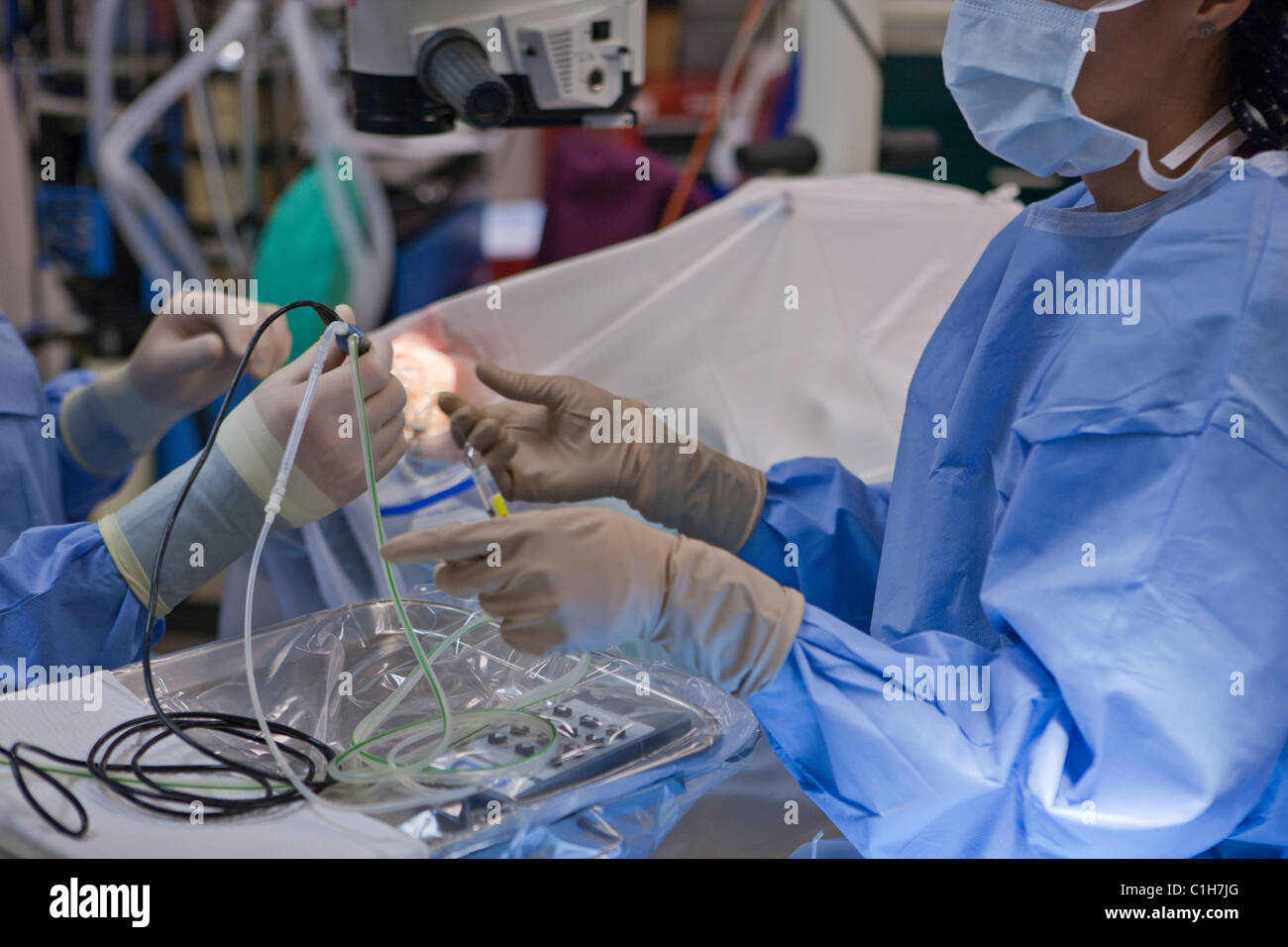 Ophthalmologist performing cataract surgery with surgical technologist ...