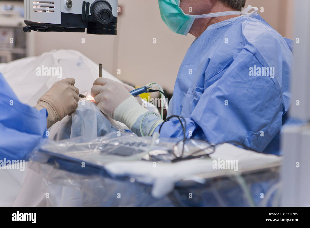 Ophthalmologist performing cataract surgery with surgical technologist ...