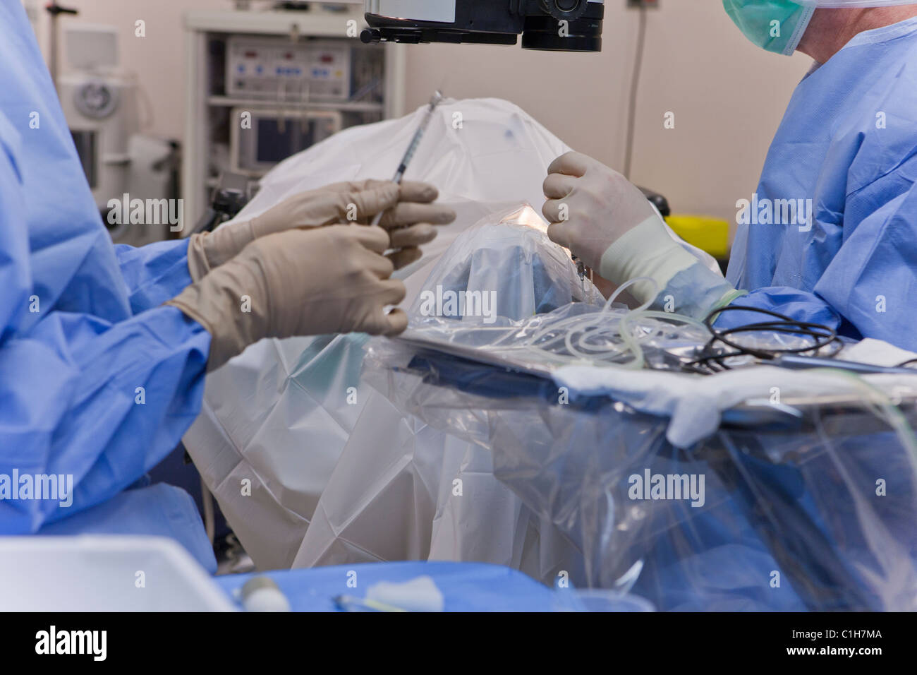Ophthalmologist performing cataract surgery with surgical technologist ...