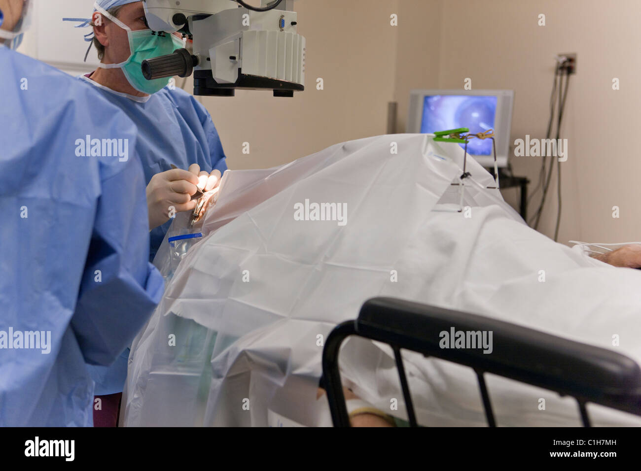 Ophthalmologist performing cataract surgery with surgical technologist ...