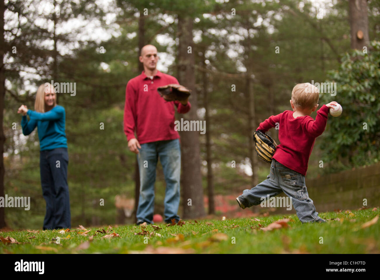 Boy playing baseball with his parents and using sign language to ...