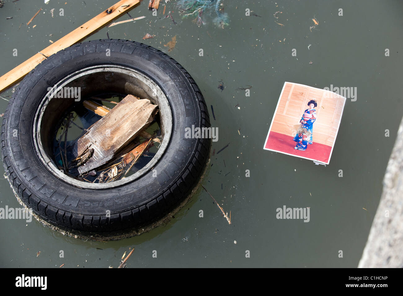 A photo of a kimono-clad woman floats next to a tire in the bay at ...