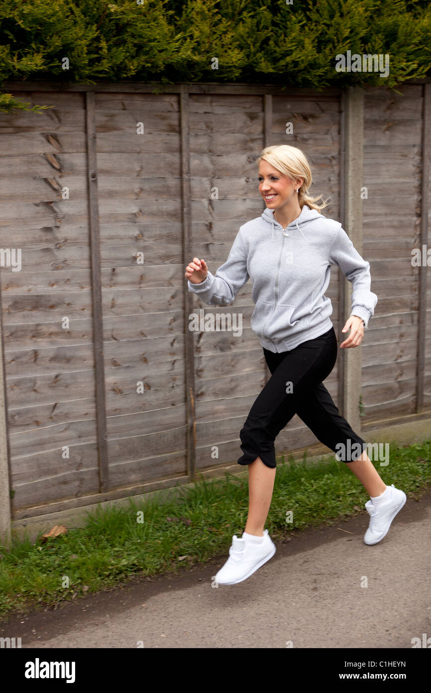 a pretty young girl outside running along a path Stock Photo - Alamy