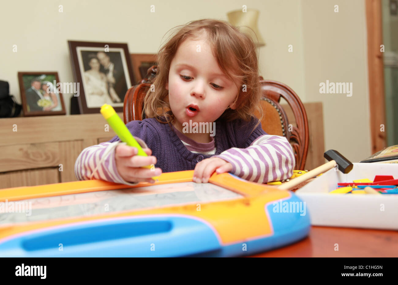 Younf girl playing with her drawing board Stock Photo - Alamy