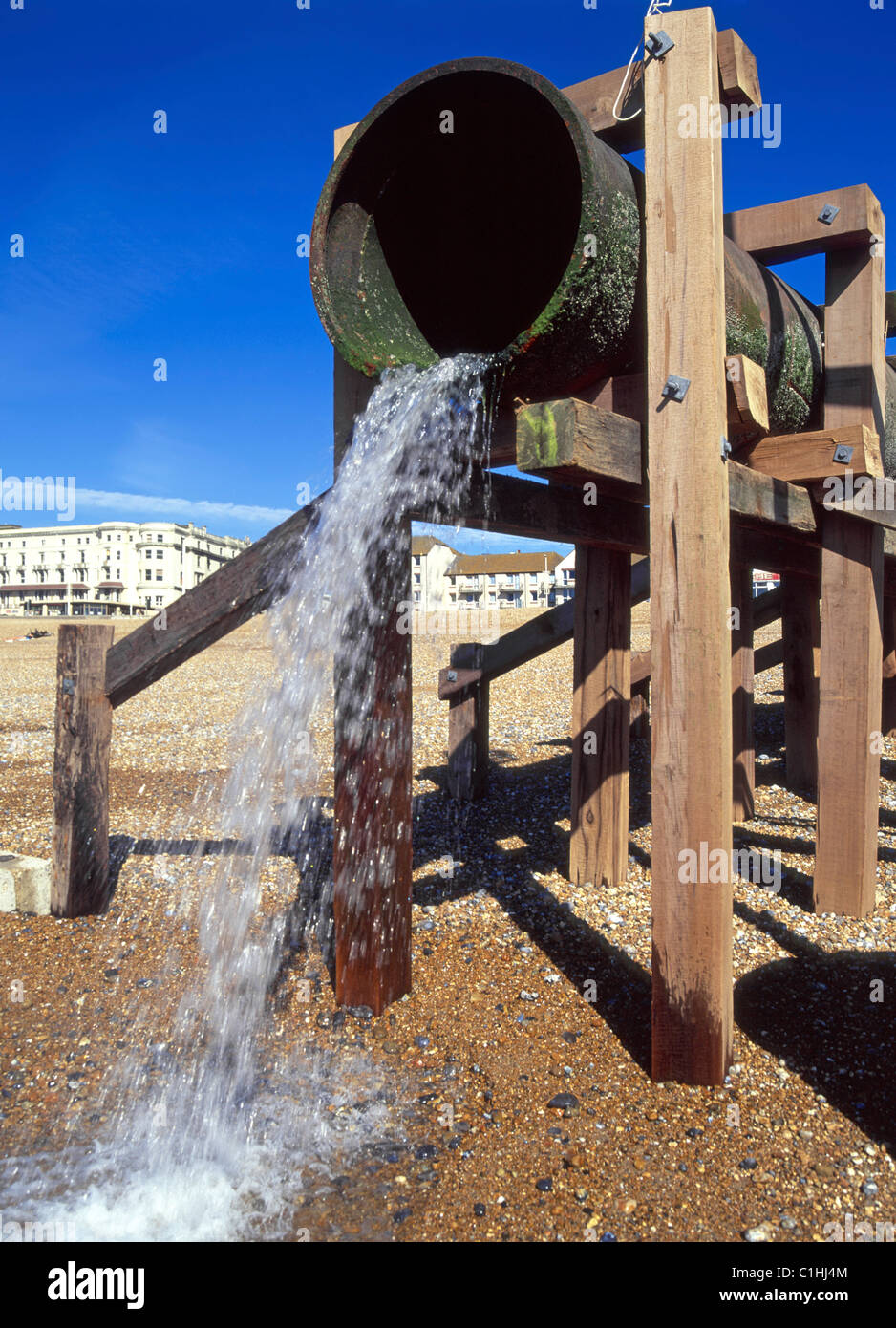 Close up large diameter water outfall drain pipe discharging on beach ...