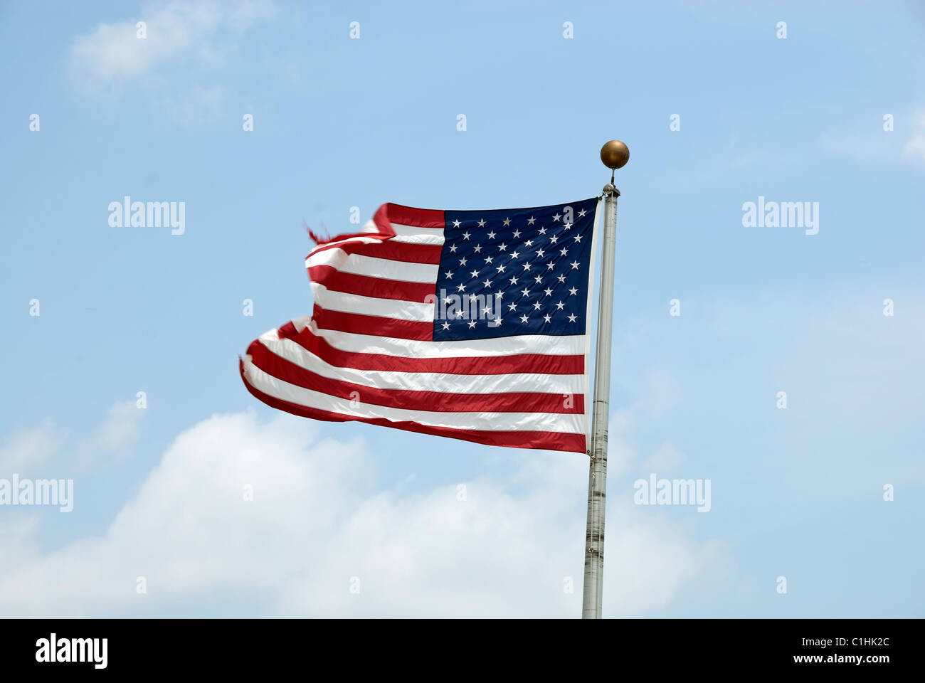 a ripped american flag fluing high with the wind Stock Photo - Alamy