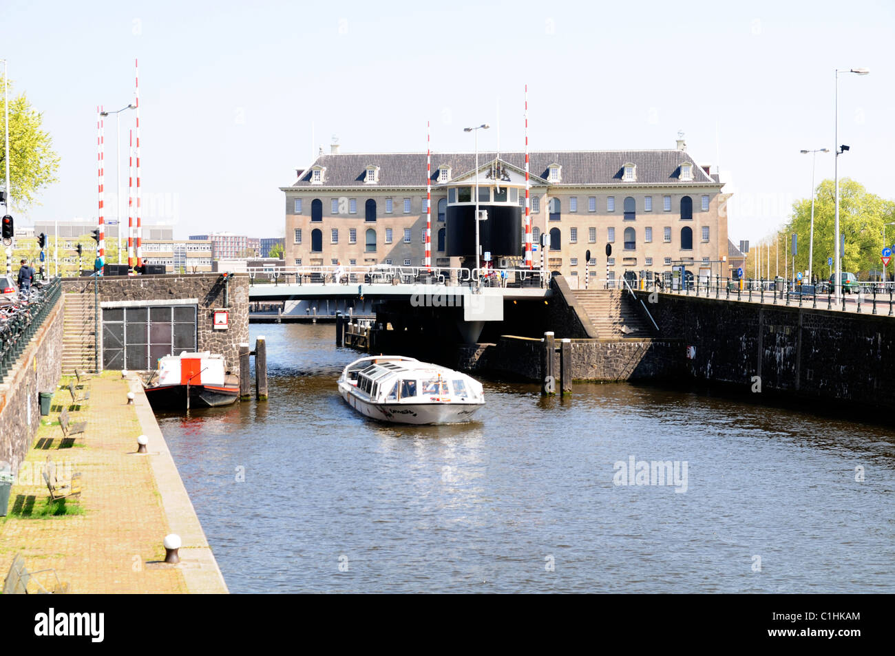 Tour boat going under a canal bridge in Amsterdam Stock Photo - Alamy