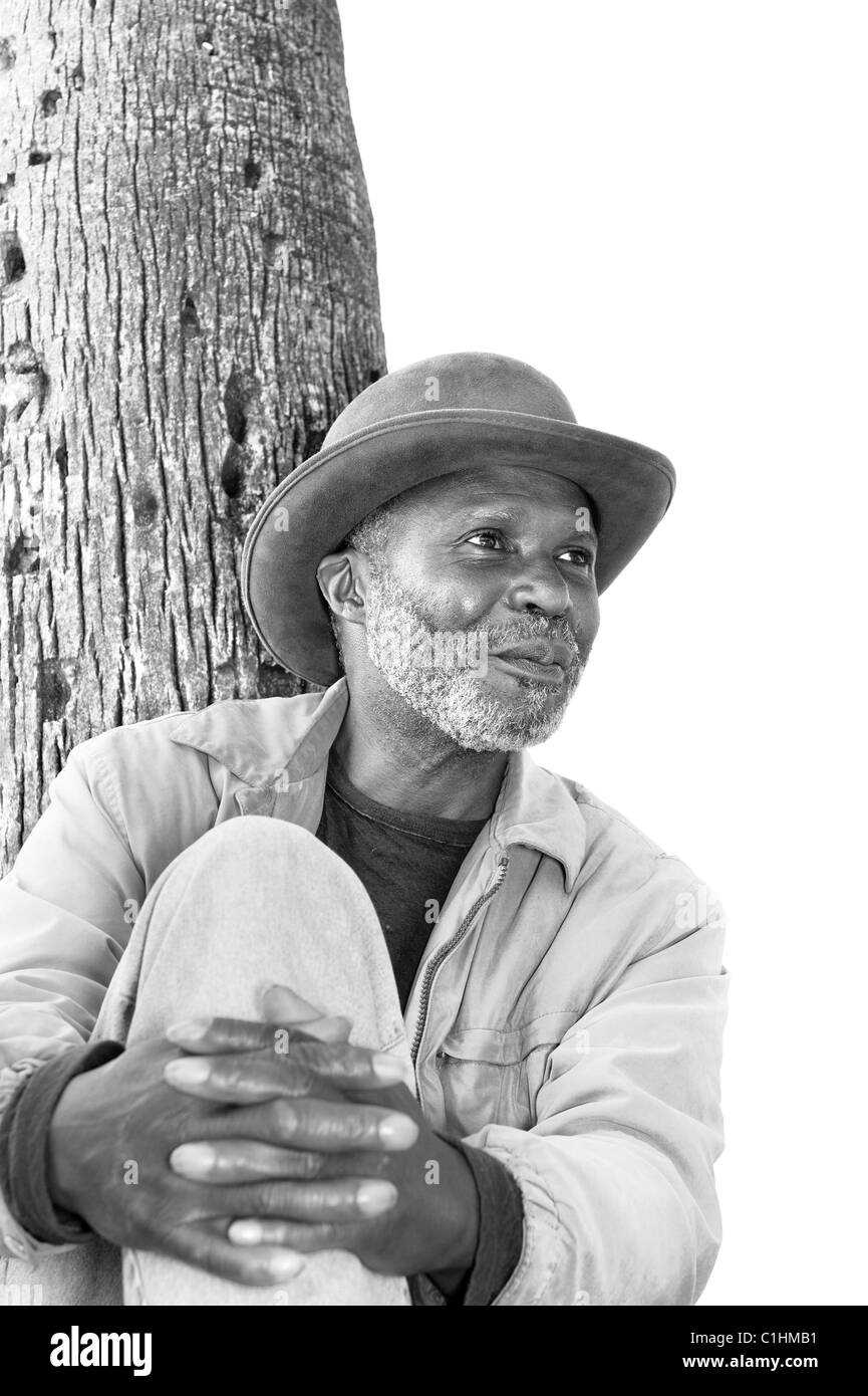 An elderly black man with a scruffy gray beard relaxes at a park on a ...