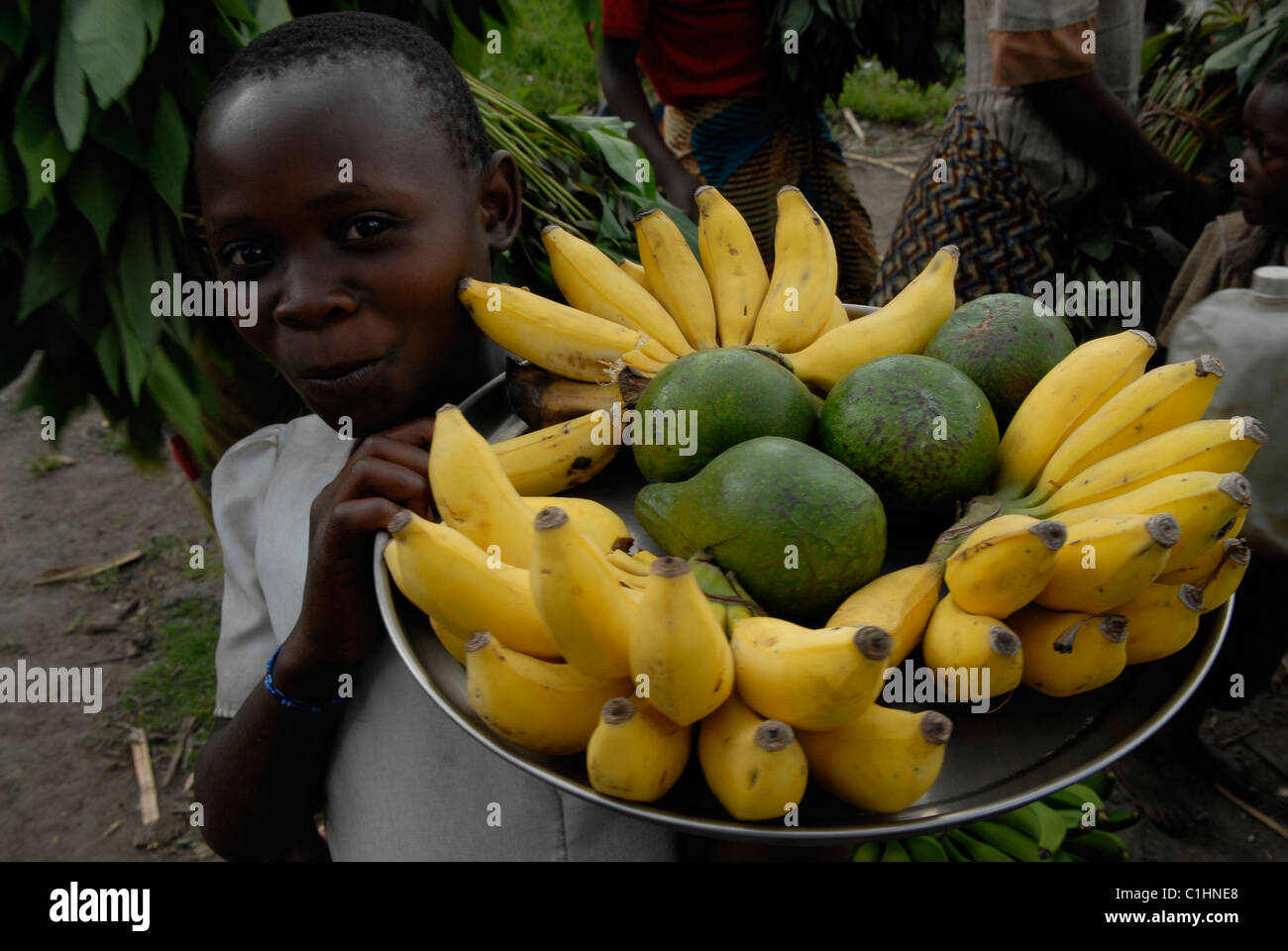 Young girl holds bunch of bananas and avocado in the market in North ...