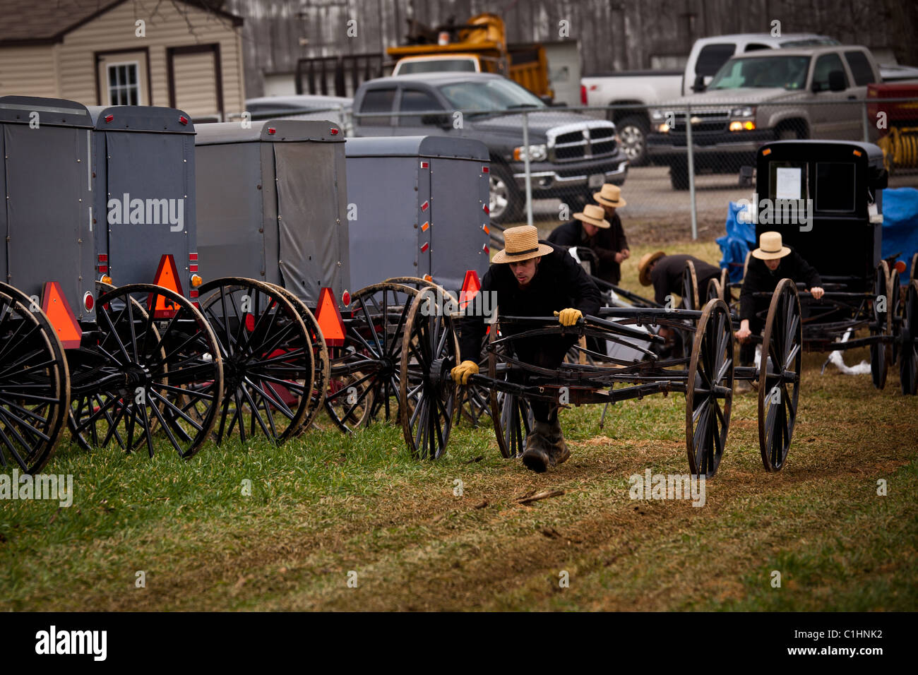Amish man pushes a buggy ready for auction during the Annual Mud Sale ...
