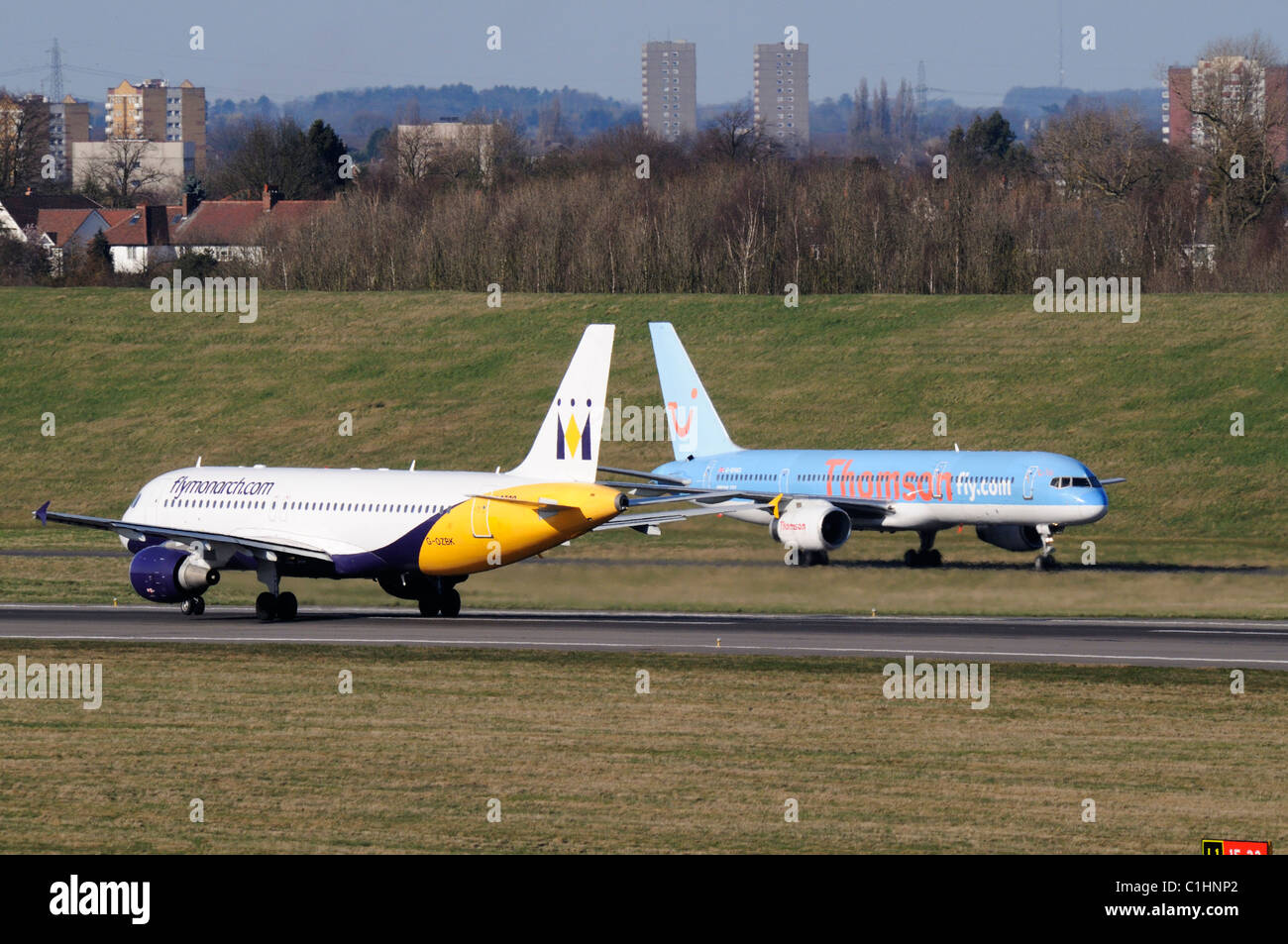 A Monarch Airlines Airbus A320 departs past a Thomson Boeing 757 that ...