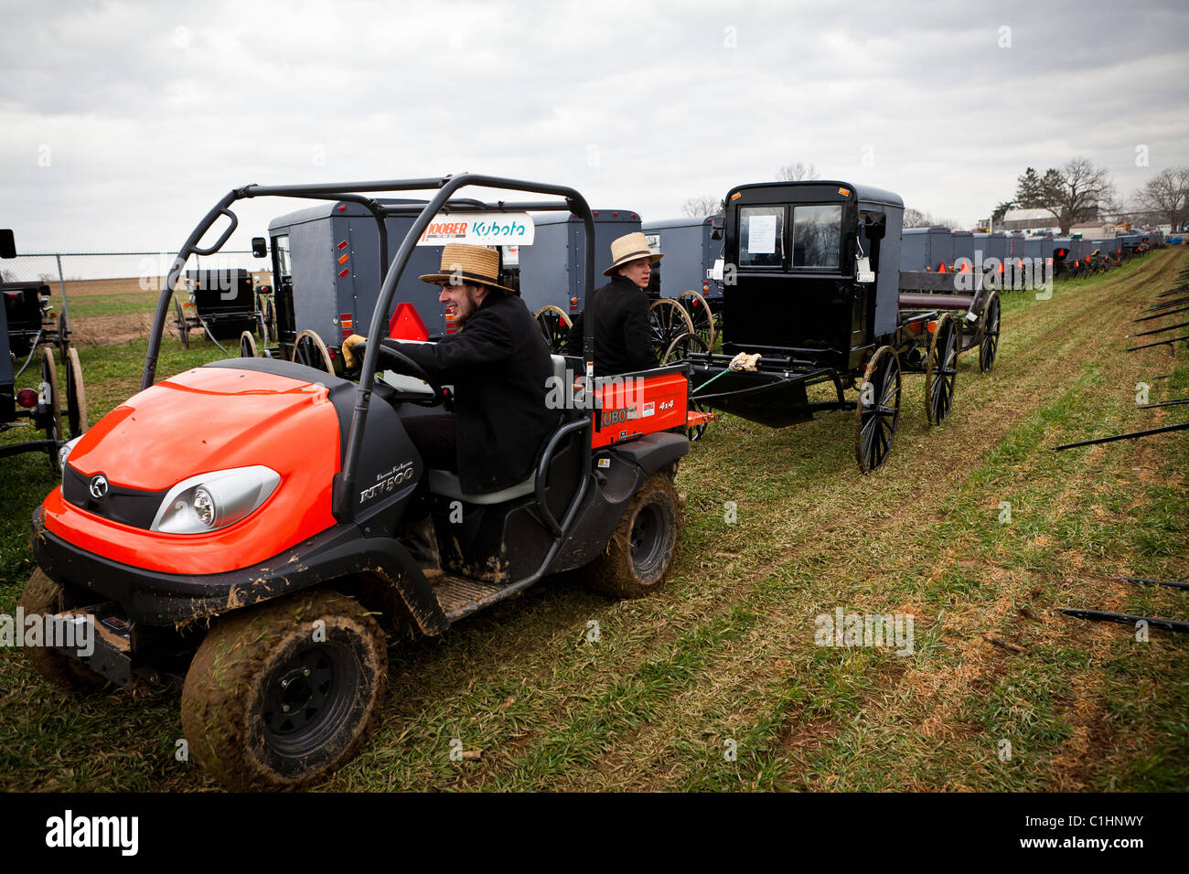 Amish men move buggies using a tractor during the Annual Mud Sale to ...