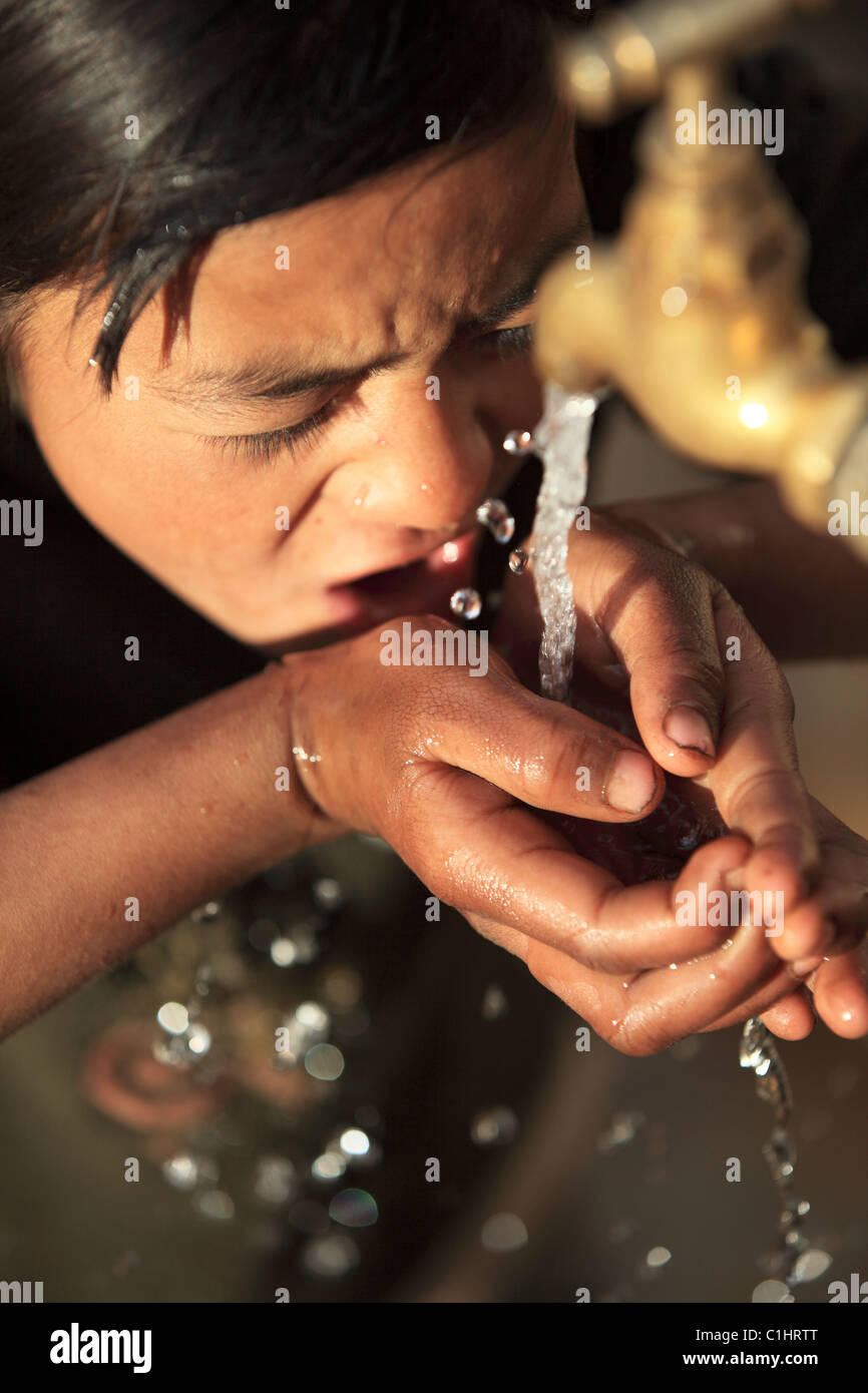 Nepali girl drinking water in Nepal Stock Photo - Alamy