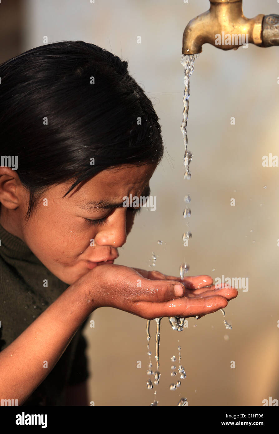 Nepali girl drinking water in Nepal Stock Photo - Alamy