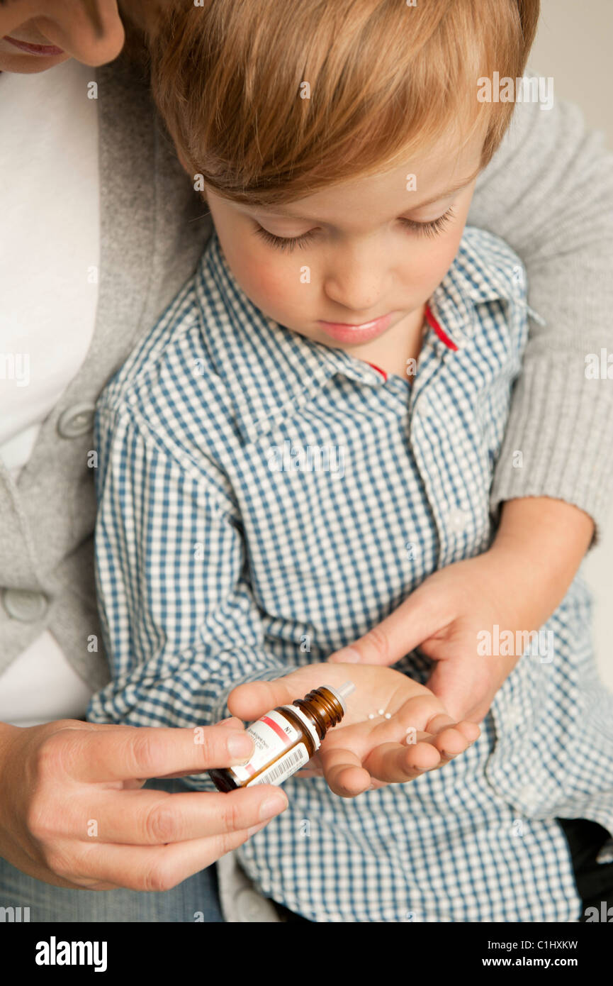 Mother giving son medicine Stock Photo - Alamy