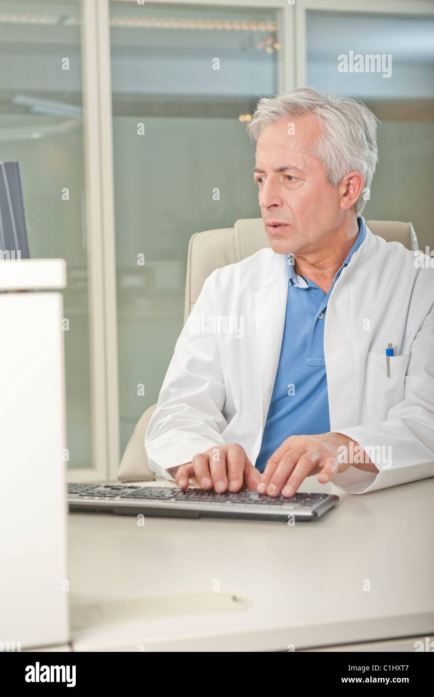 Doctor using computer at desk Stock Photo - Alamy