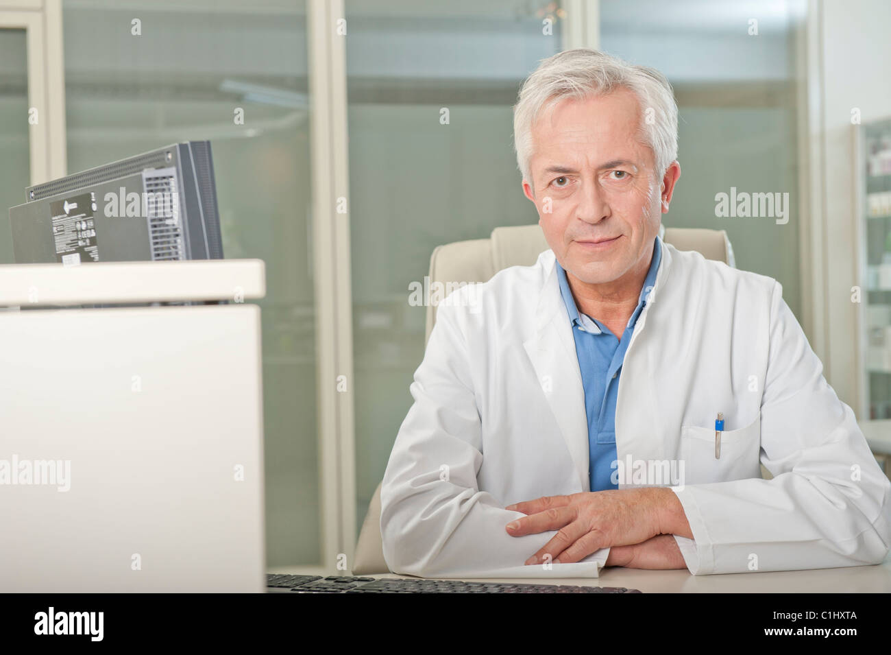 Serious doctor sitting behind hi-res stock photography and images - Alamy