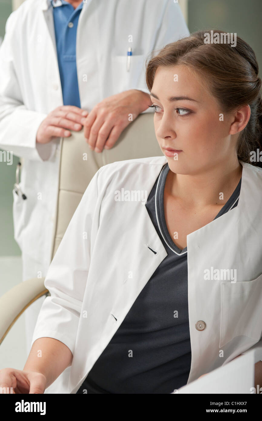 Doubtful doctor's assistant turning round Stock Photo - Alamy