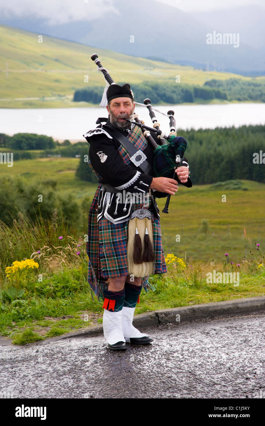Scottish piper in traditional dress playing bagpipes hi-res stock ...