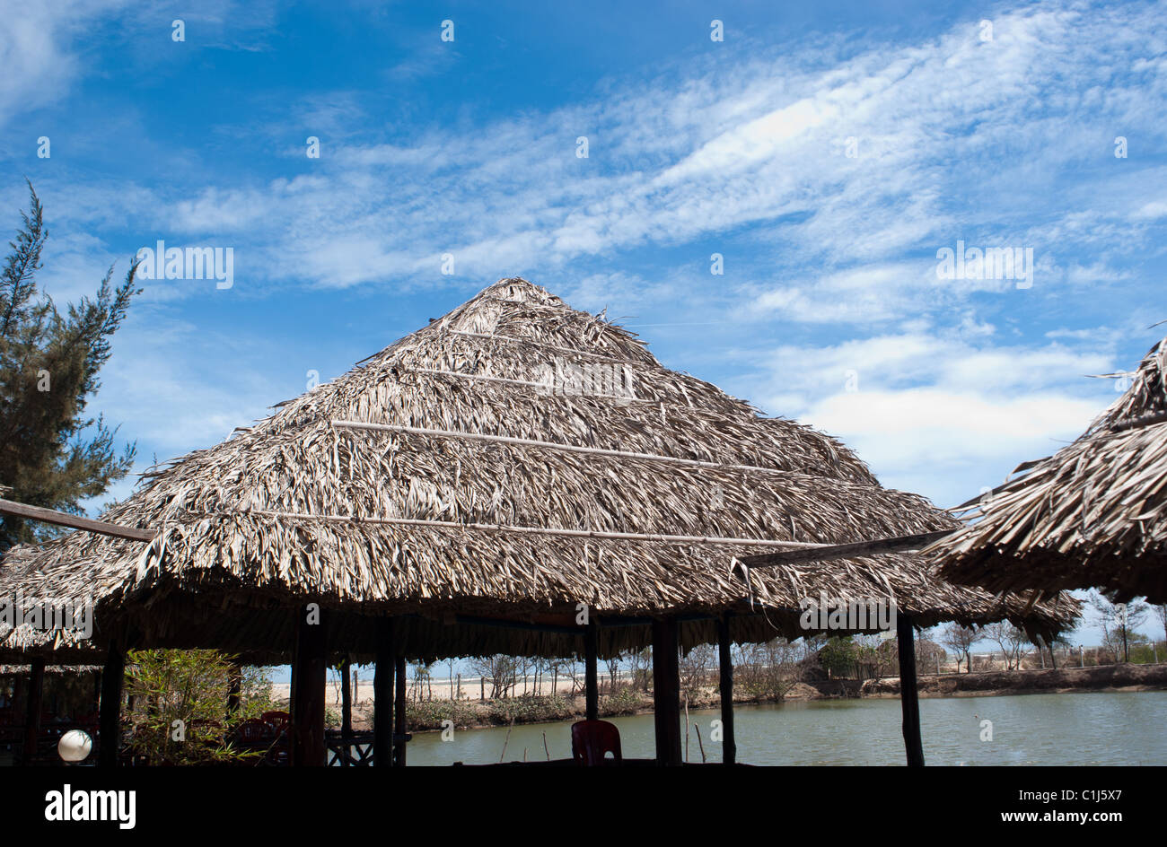 Straw hut facing water Stock Photo - Alamy