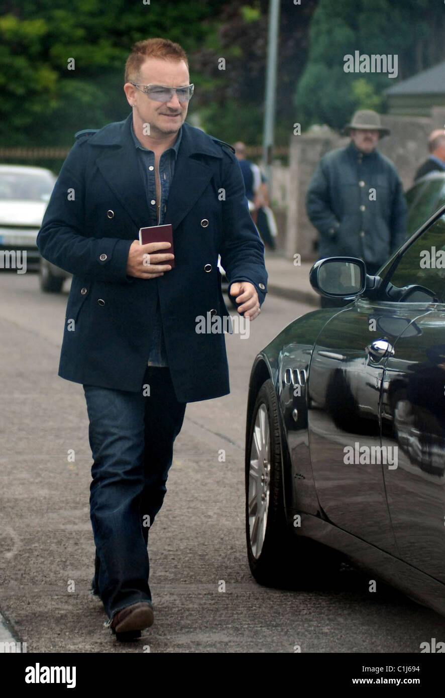 Bono arriving at his local polling station carrying his voting card and ...