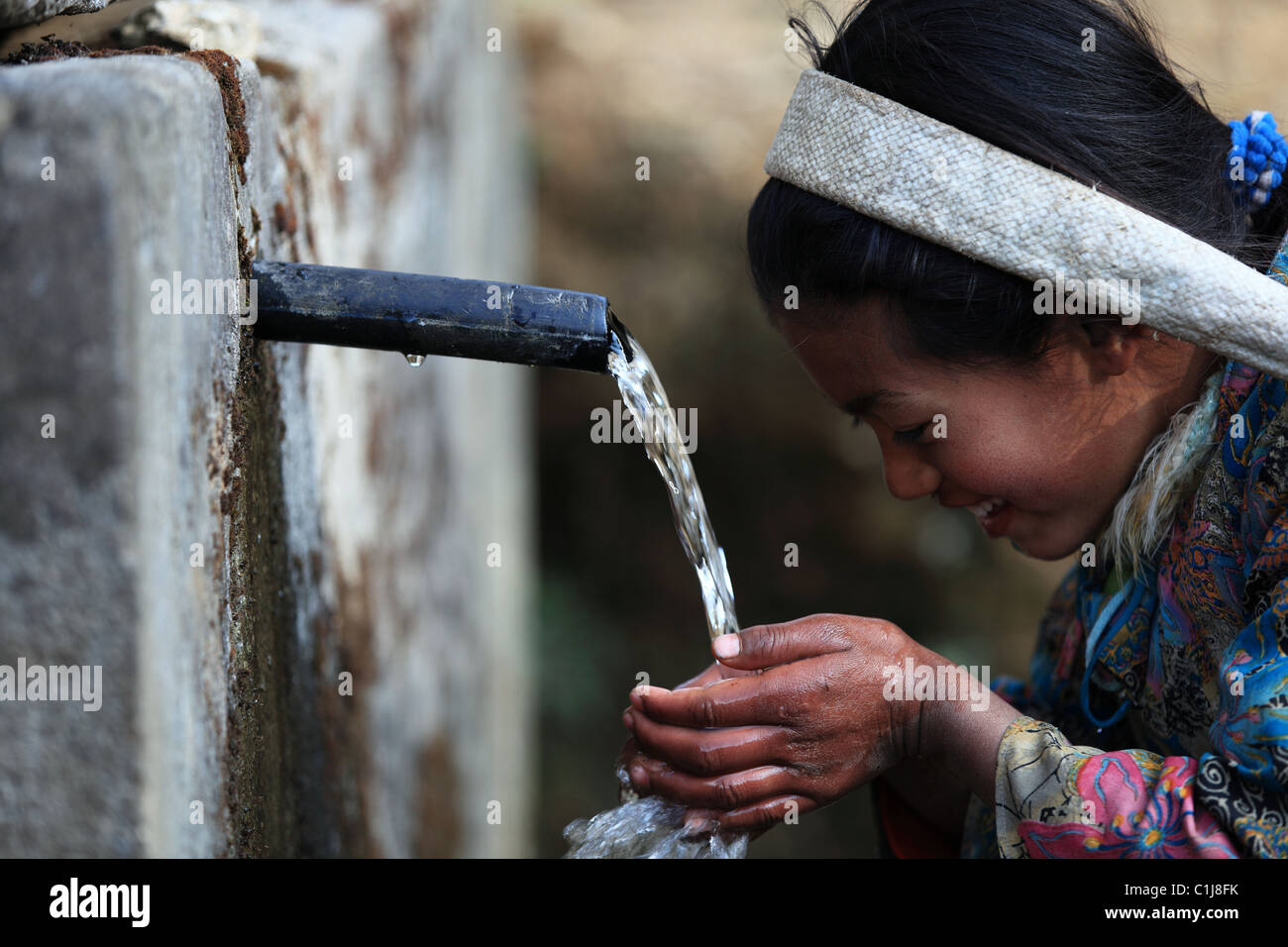 Nepali girl drinking water in Nepal Stock Photo - Alamy