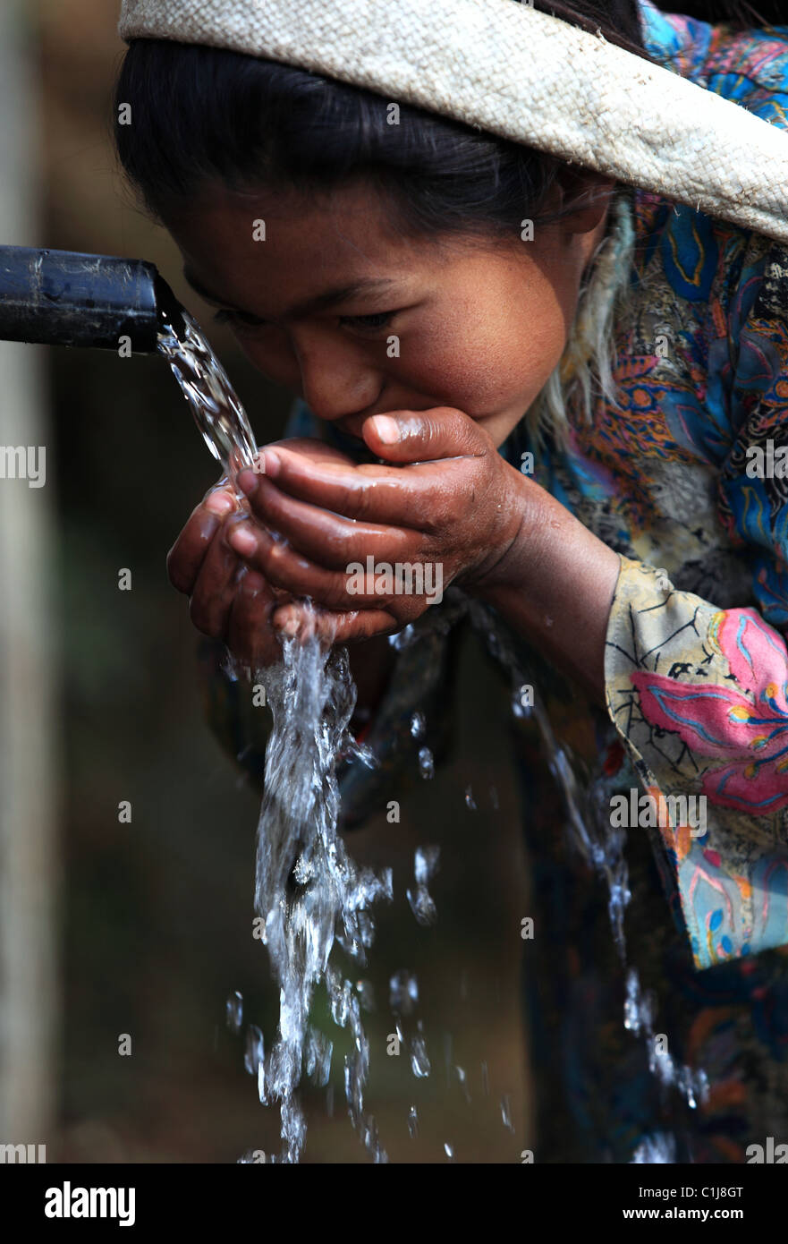 Nepali girl drinking water in Nepal Stock Photo - Alamy