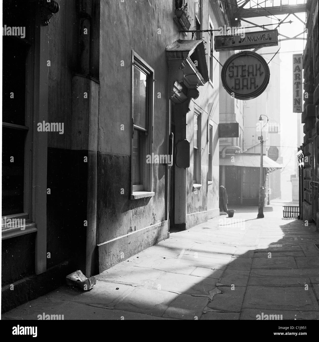 1950s, historical, a sign advertising a Steak Bar above an uneven ...