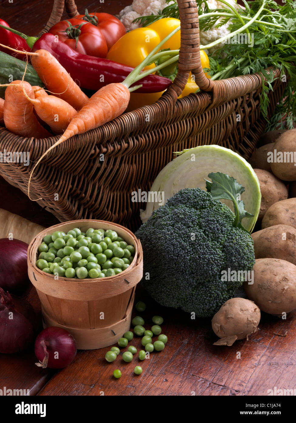 Wicker basket raw vegetables tomatoes sweet red yellow peppers carrots ...