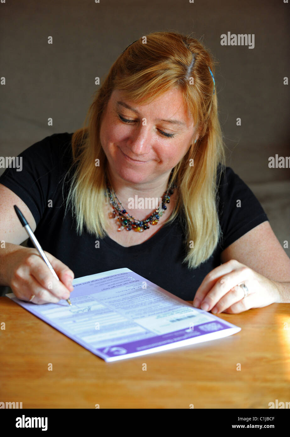 A woman filling out the UK 2011 census form at home Stock Photo - Alamy