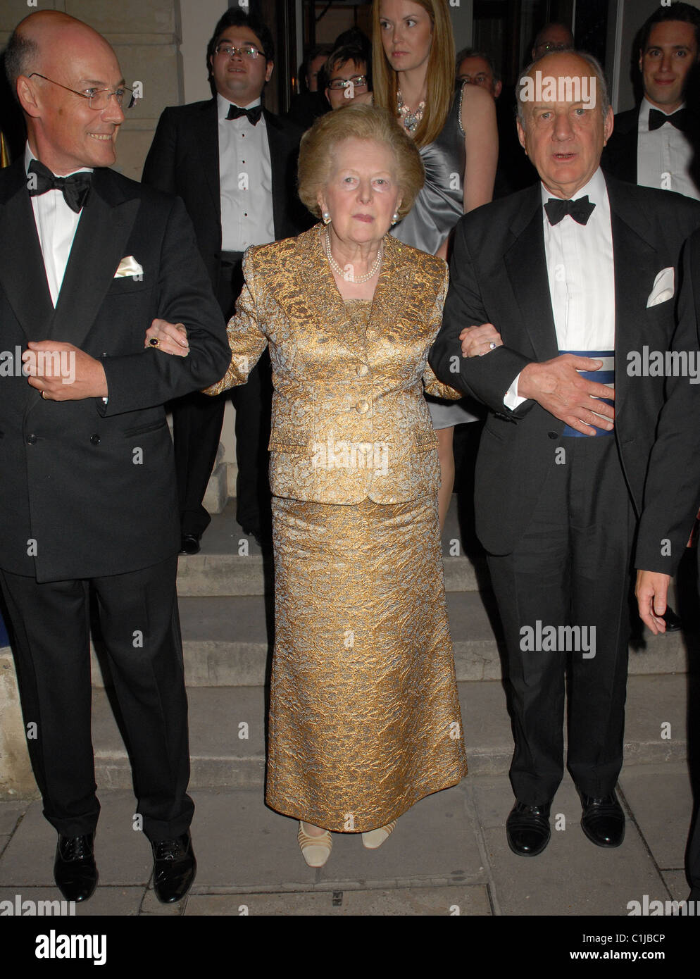 Former British Prime Minister Margaret Thatcher in a gold evening dress ...