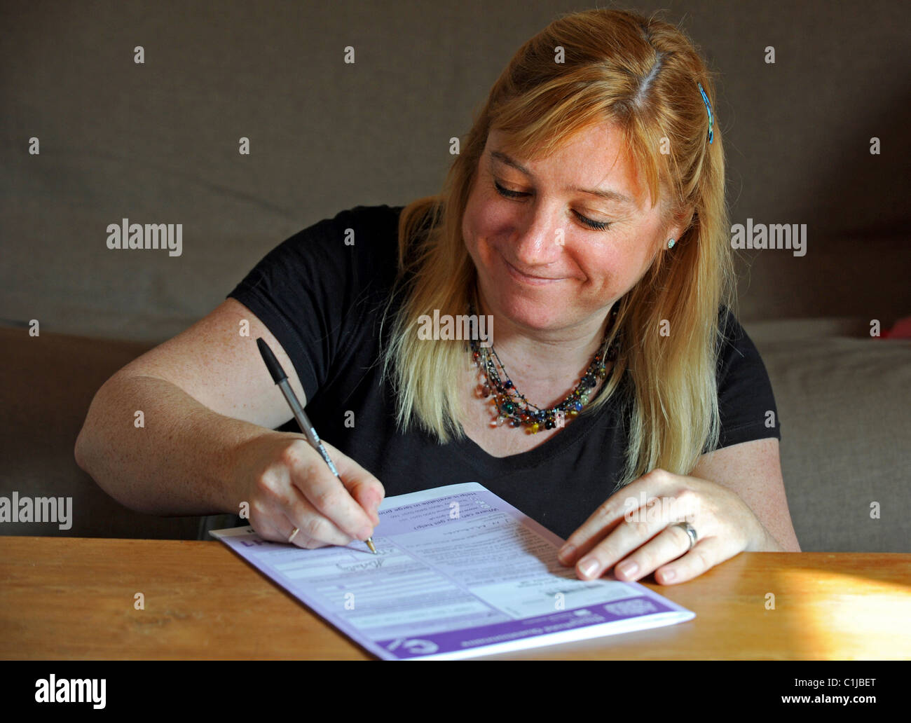 A woman filling out the UK 2011 census form at home Stock Photo - Alamy