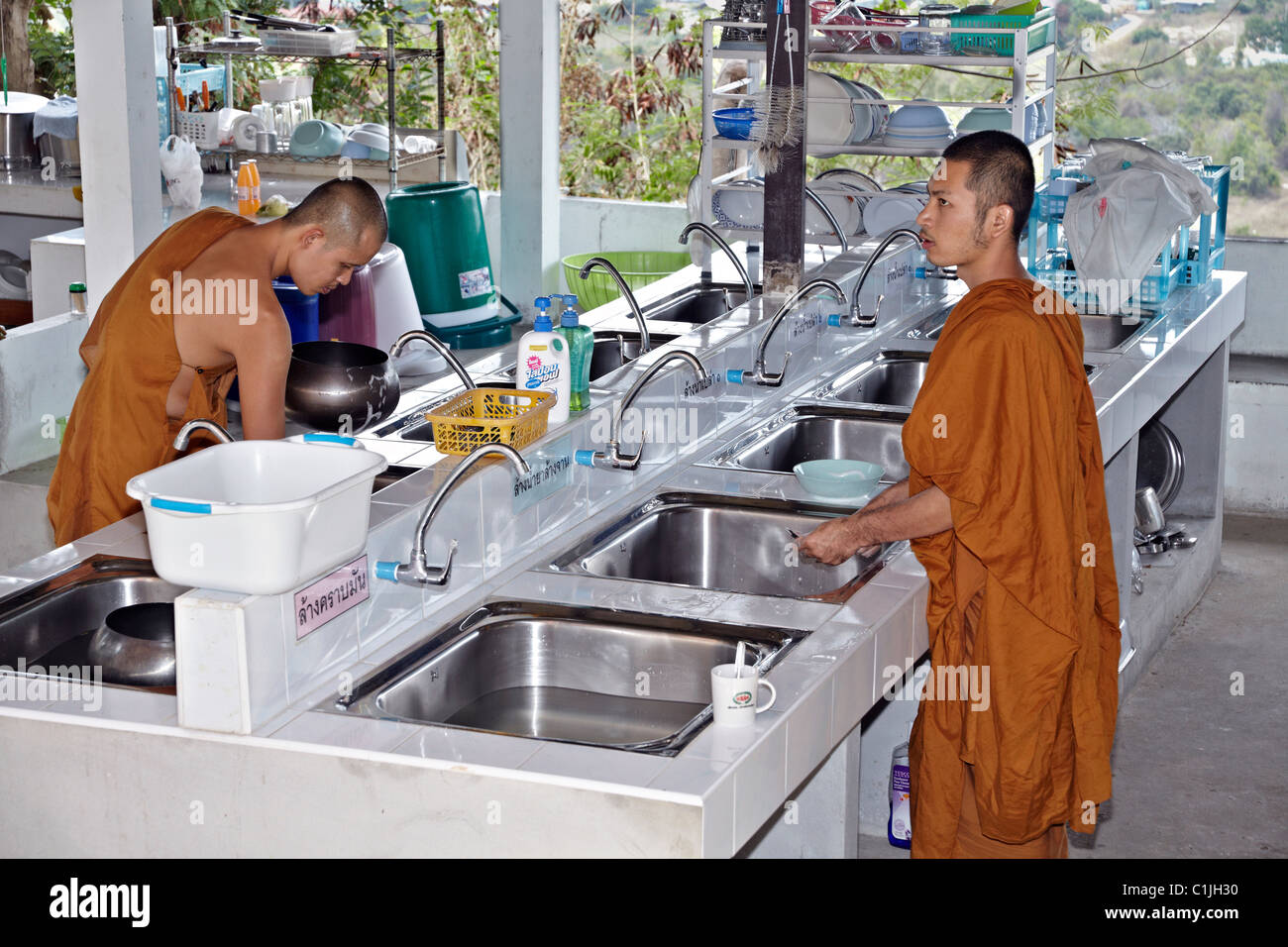 Buddhist monks attending to chores and washing dishes. Thailand S E ...