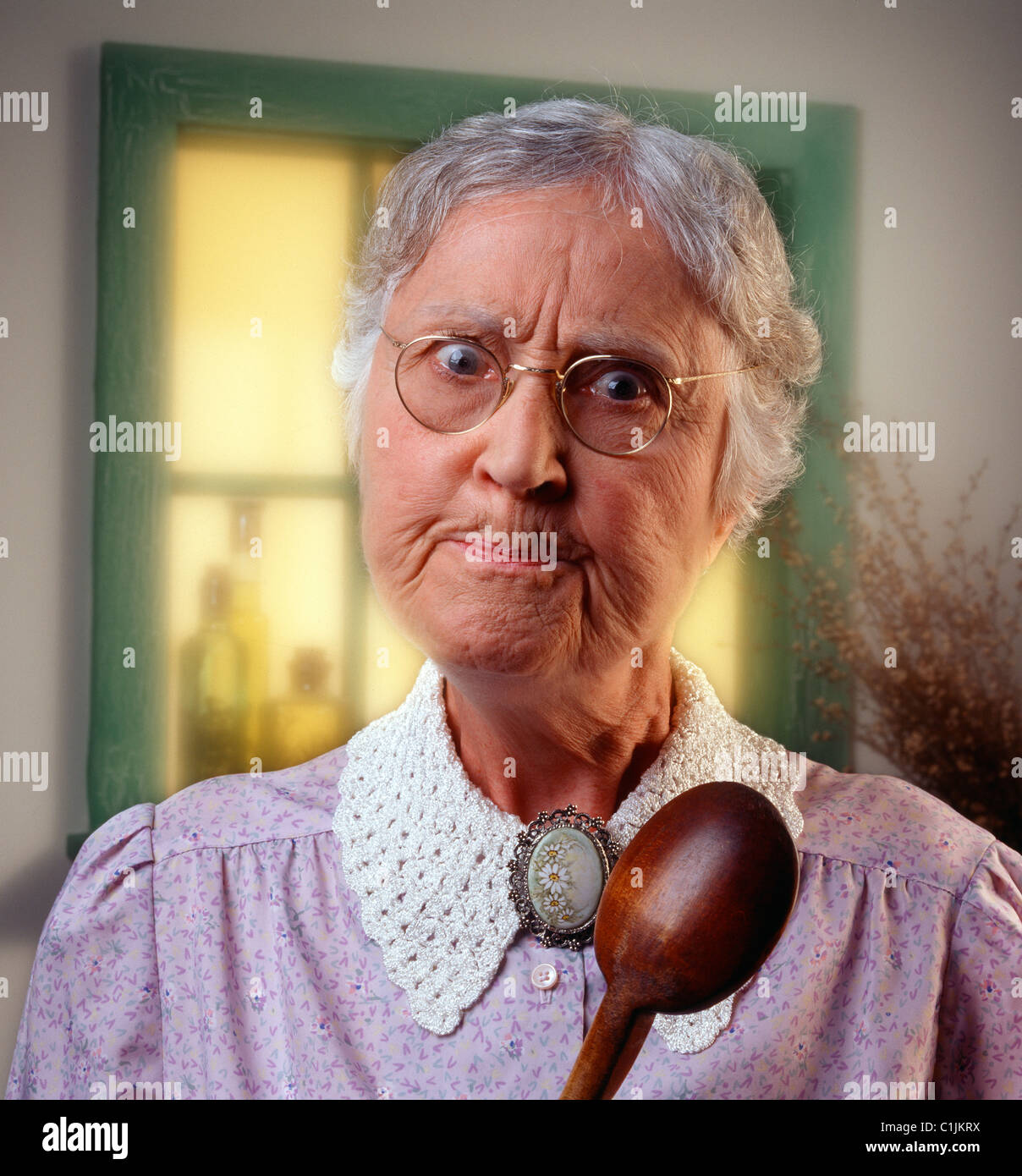 A grumpy grandma threatens with her wooden spoon Stock Photo - Alamy