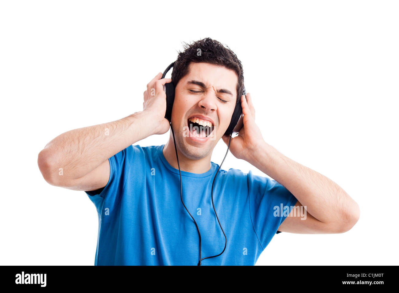Casual young man listening music with headphones, isolated on white ...