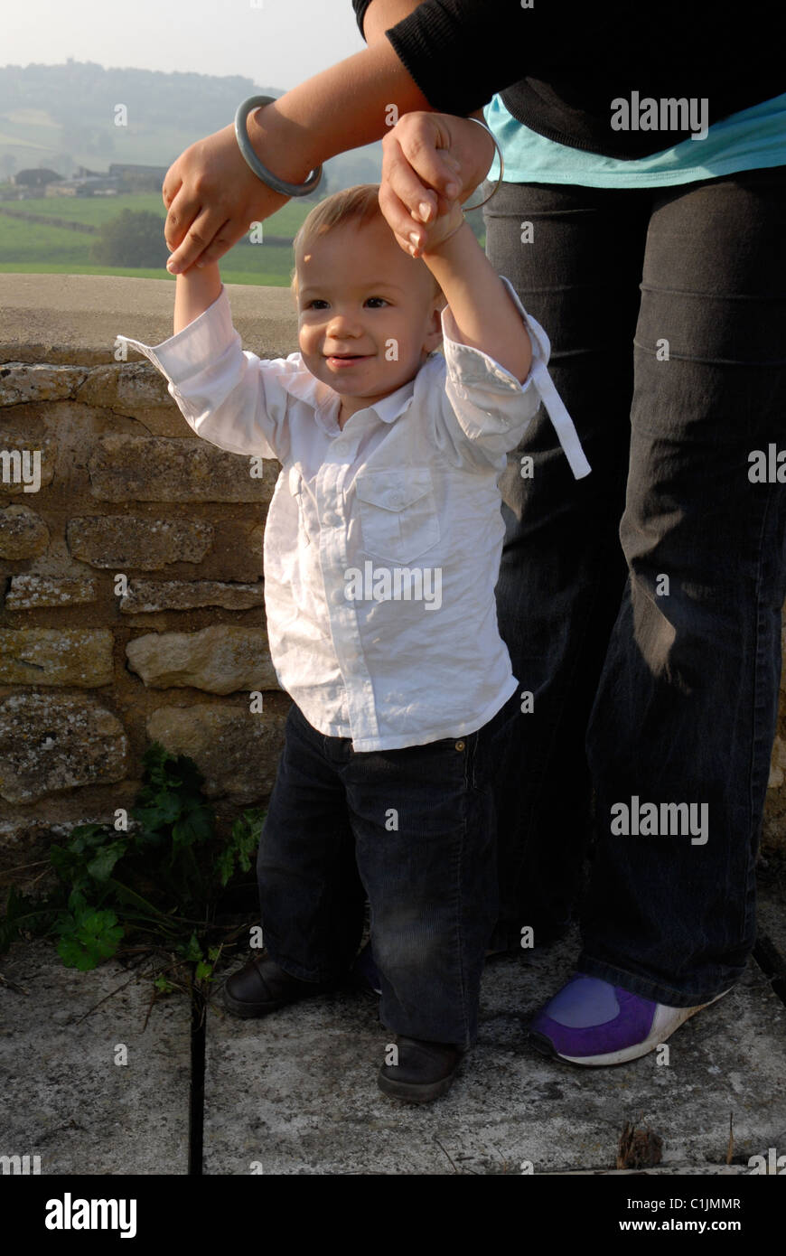Toddler learning to walk, being helped by his parent Stock Photo - Alamy