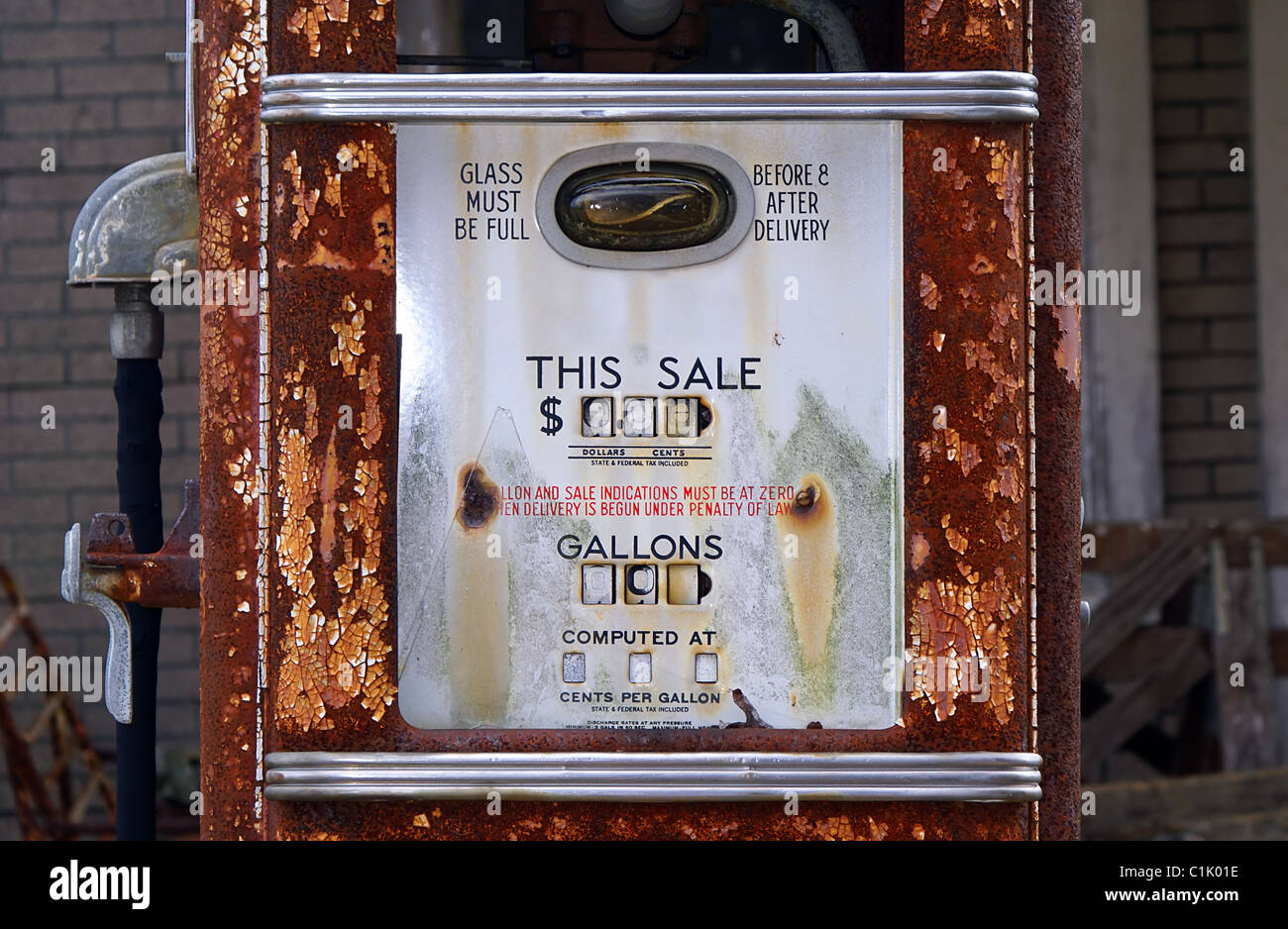 Old, rusty, vintage American gas pump in front of a brick wall with ...