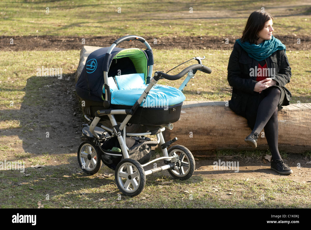 A mother with pushing pram on a bench, spring park Stock Photo - Alamy