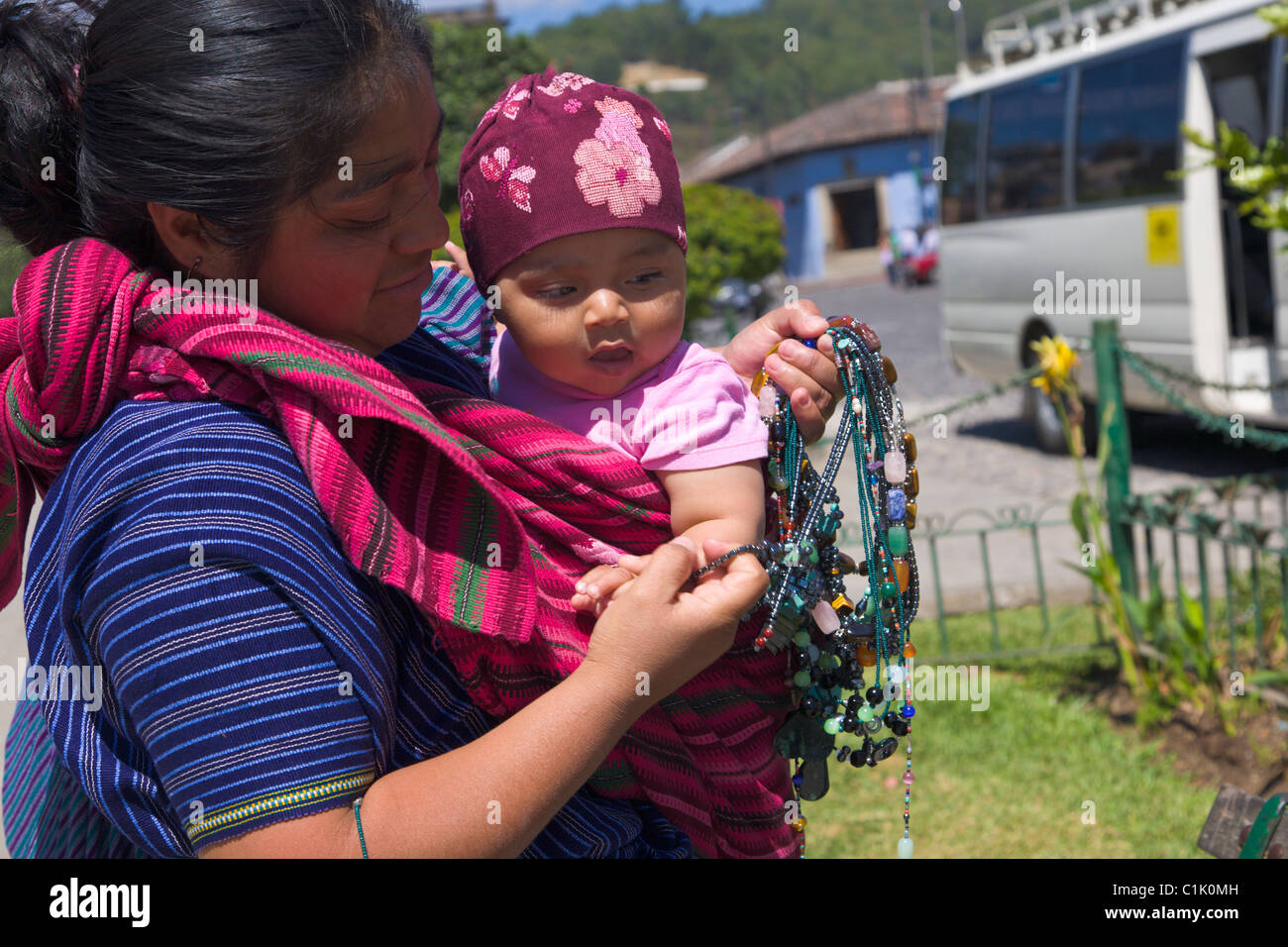 Mayan woman with baby selling souvenirs, Antigua, Guatemala Stock Photo ...