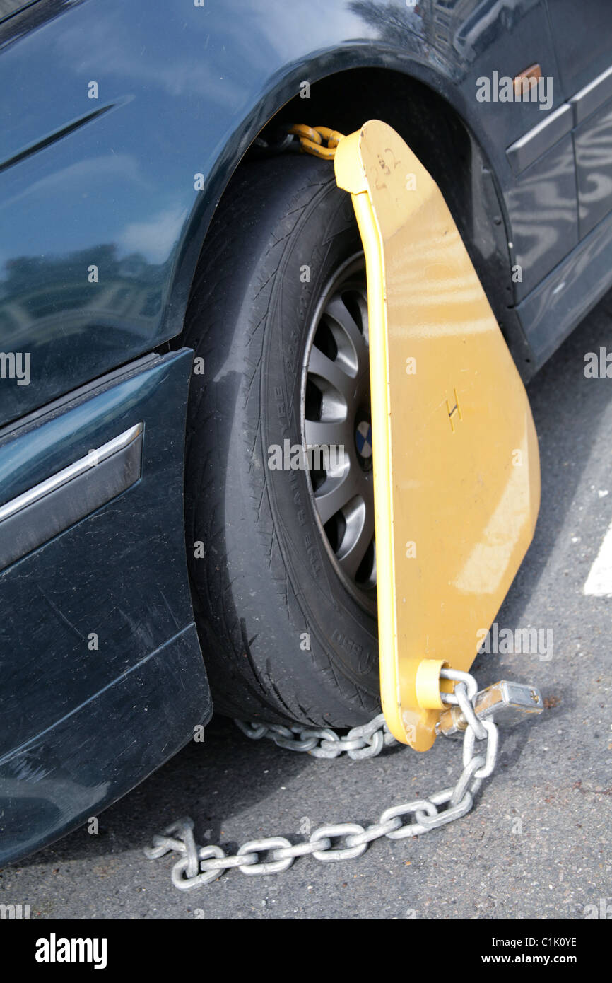 Yellow Police clamp on wheel of untaxed car Stock Photo - Alamy