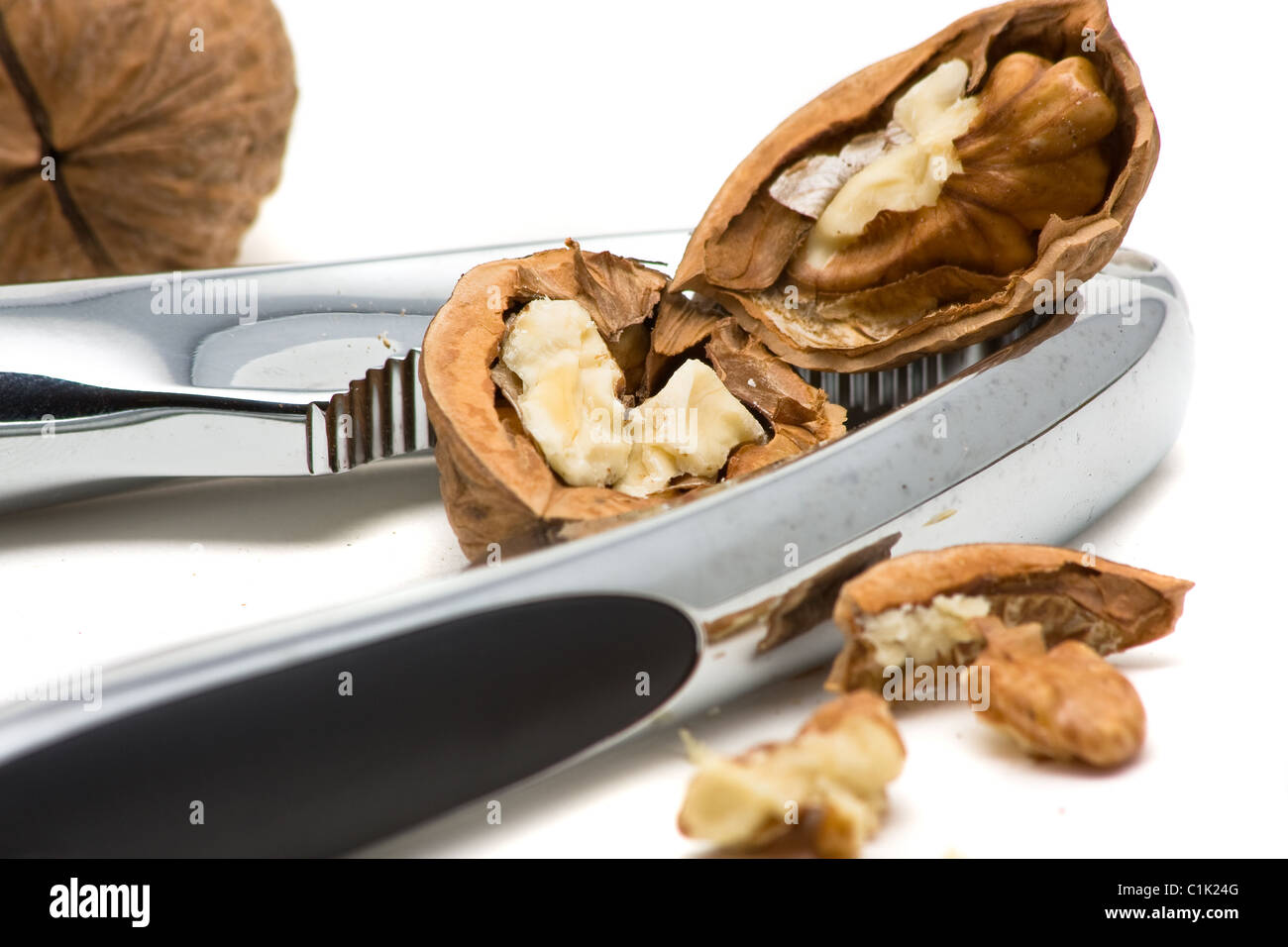Cracking walnuts with nutcracker over white background Stock Photo - Alamy
