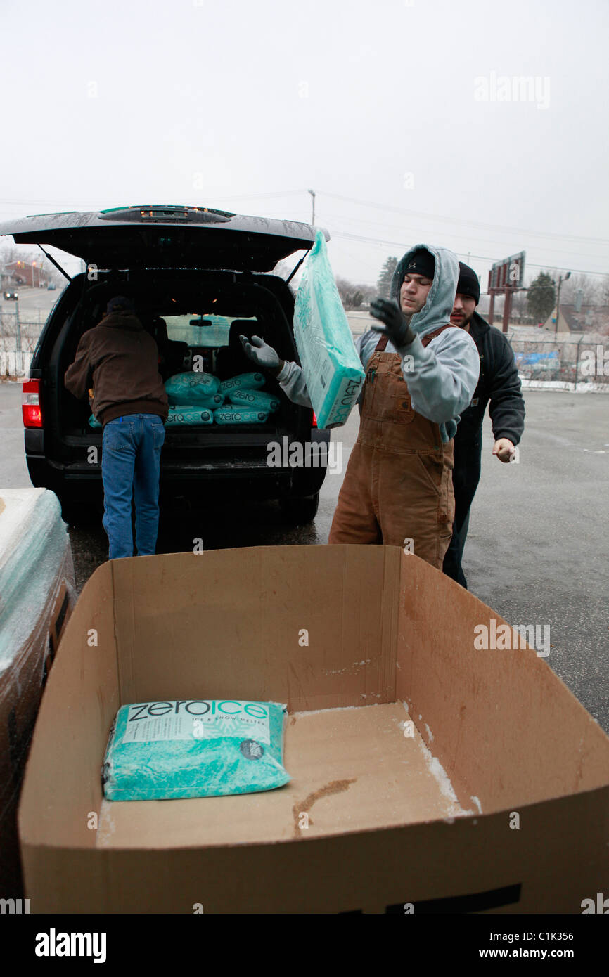 Workers at Kleindorfer's Hardware help a customer load ice melting salt ...