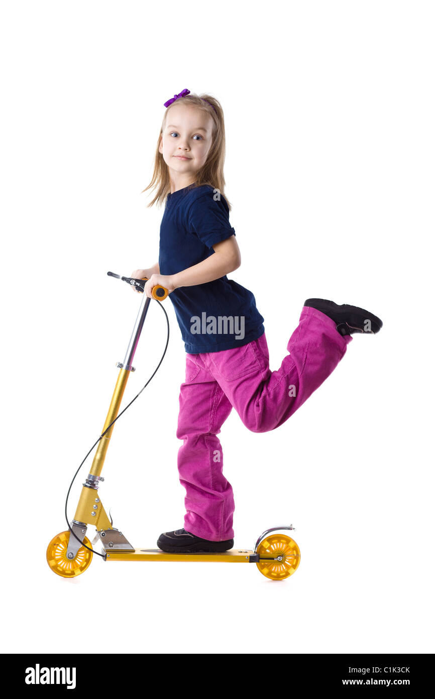 Full body shot of a young girl riding her scooter, looking at the ...