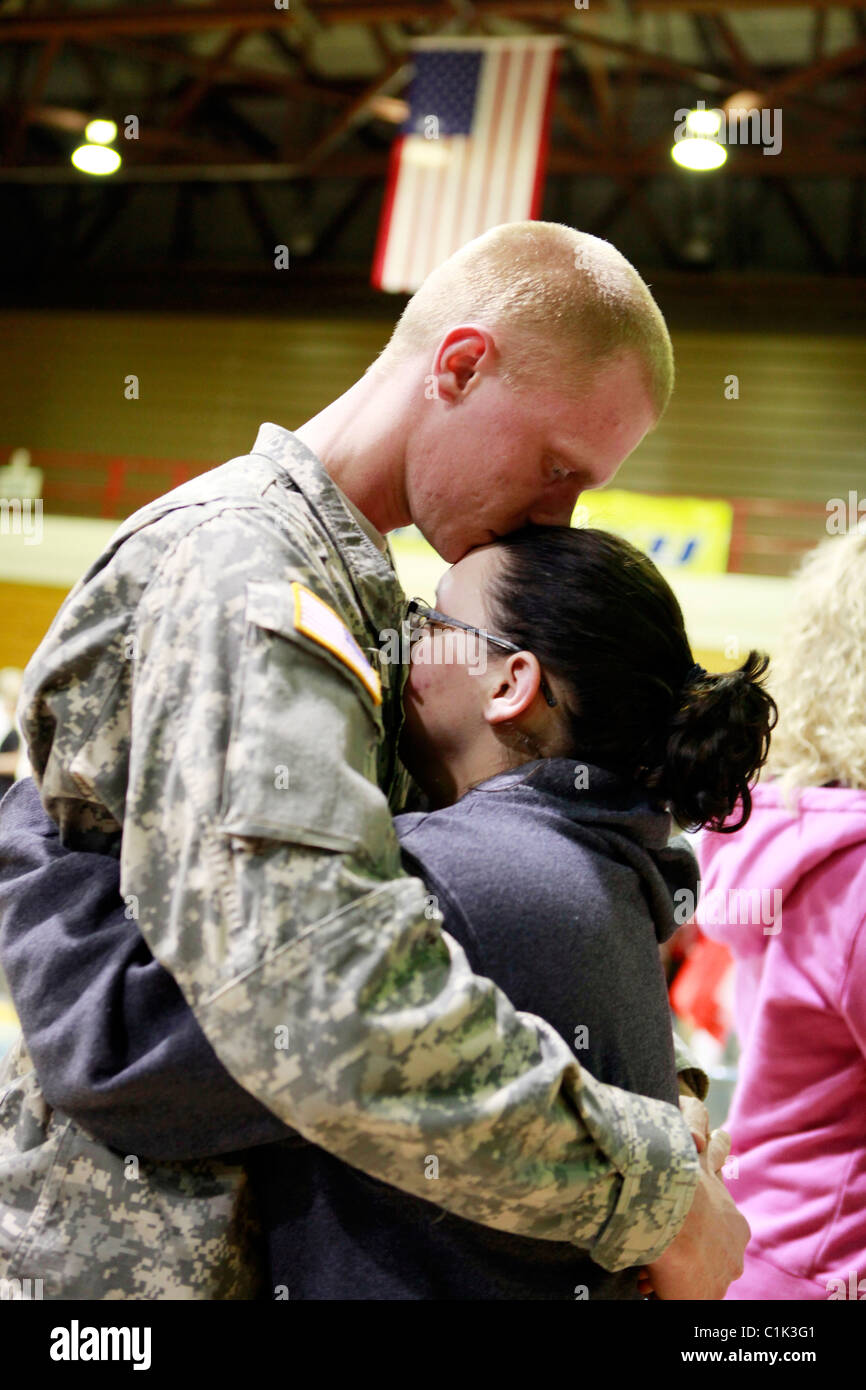 A soldier hugs a family member during a ceremony for the Bedford, Ind ...