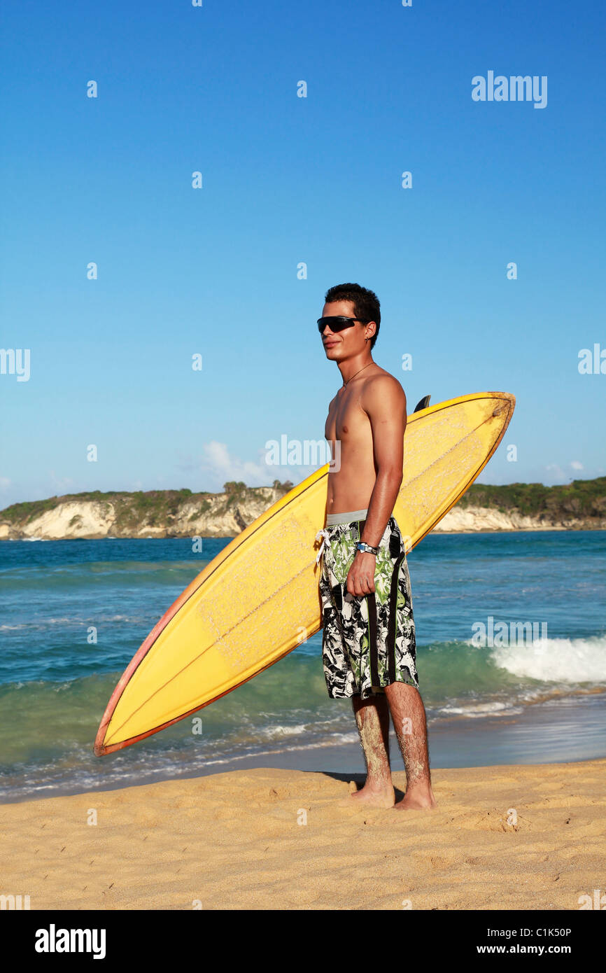 Surfer holding a surfboard on beach Stock Photo - Alamy