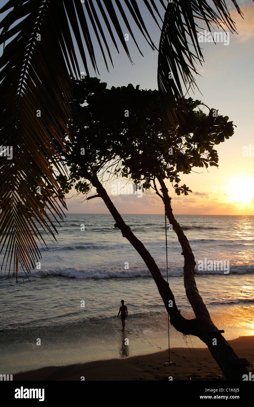 A lone woman on a tropical beach at sunset, Punta Banco, Costa Rica ...
