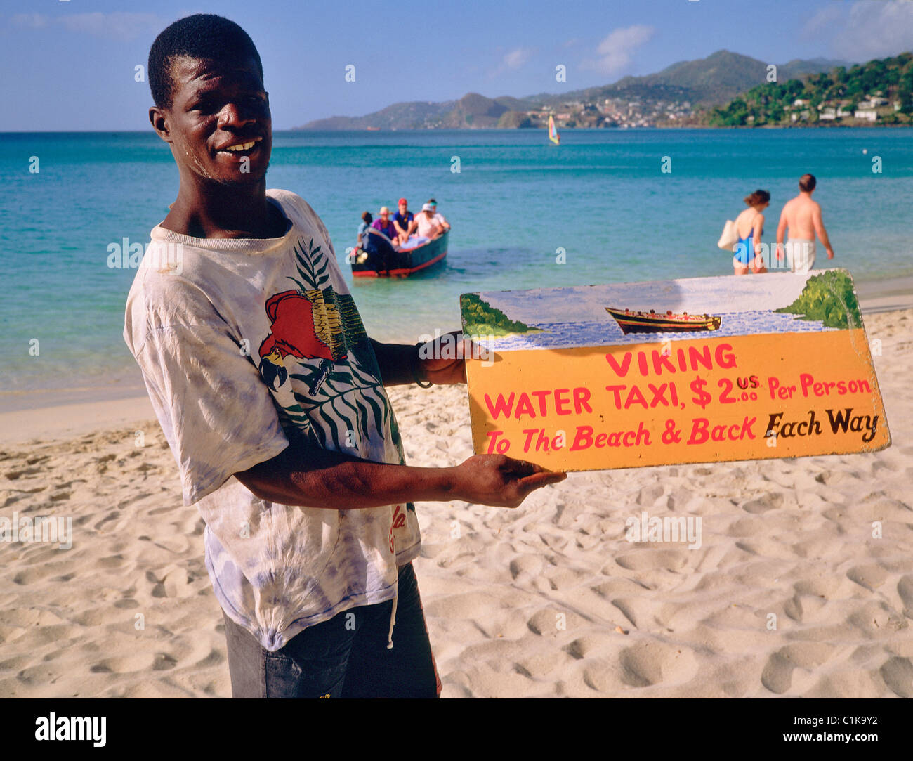 Grenada Island, Grand Anse Beach, Man proposing a water taxi with his ...