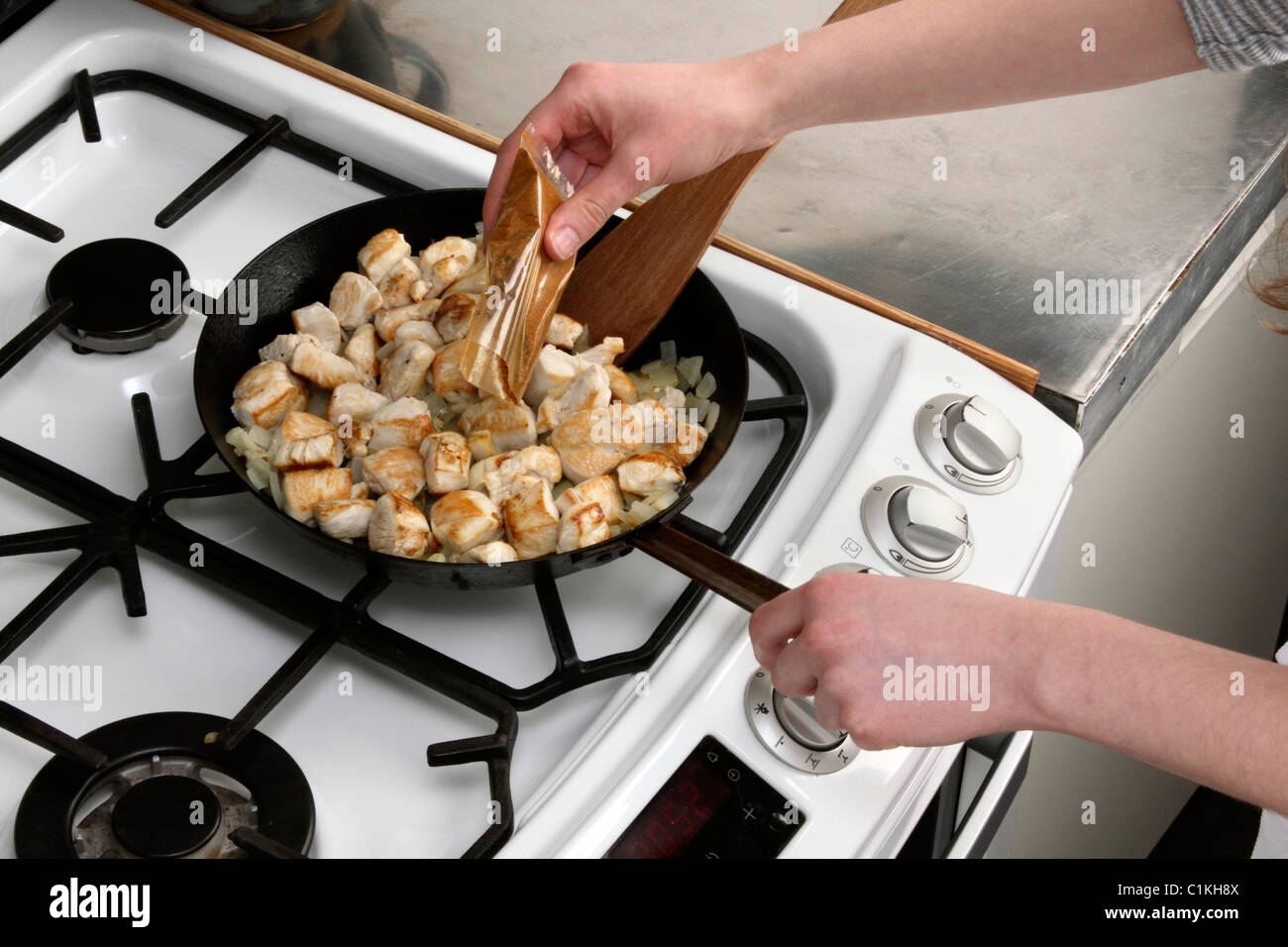 Adding spice mix to frying chicken pieces step by step Stock Photo - Alamy