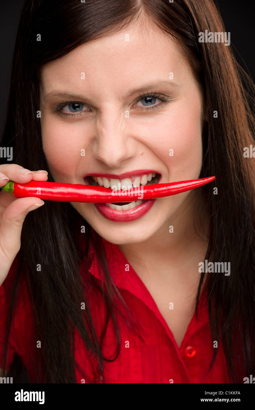 Chili pepper - portrait young woman bite red spicy vegetable Stock ...